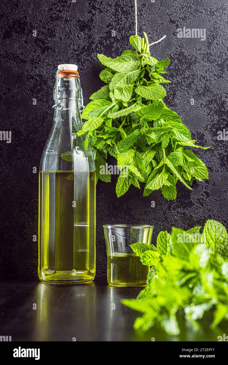 Sweet mint syrup and mint leaves on the black table Stock Photo - Alamy