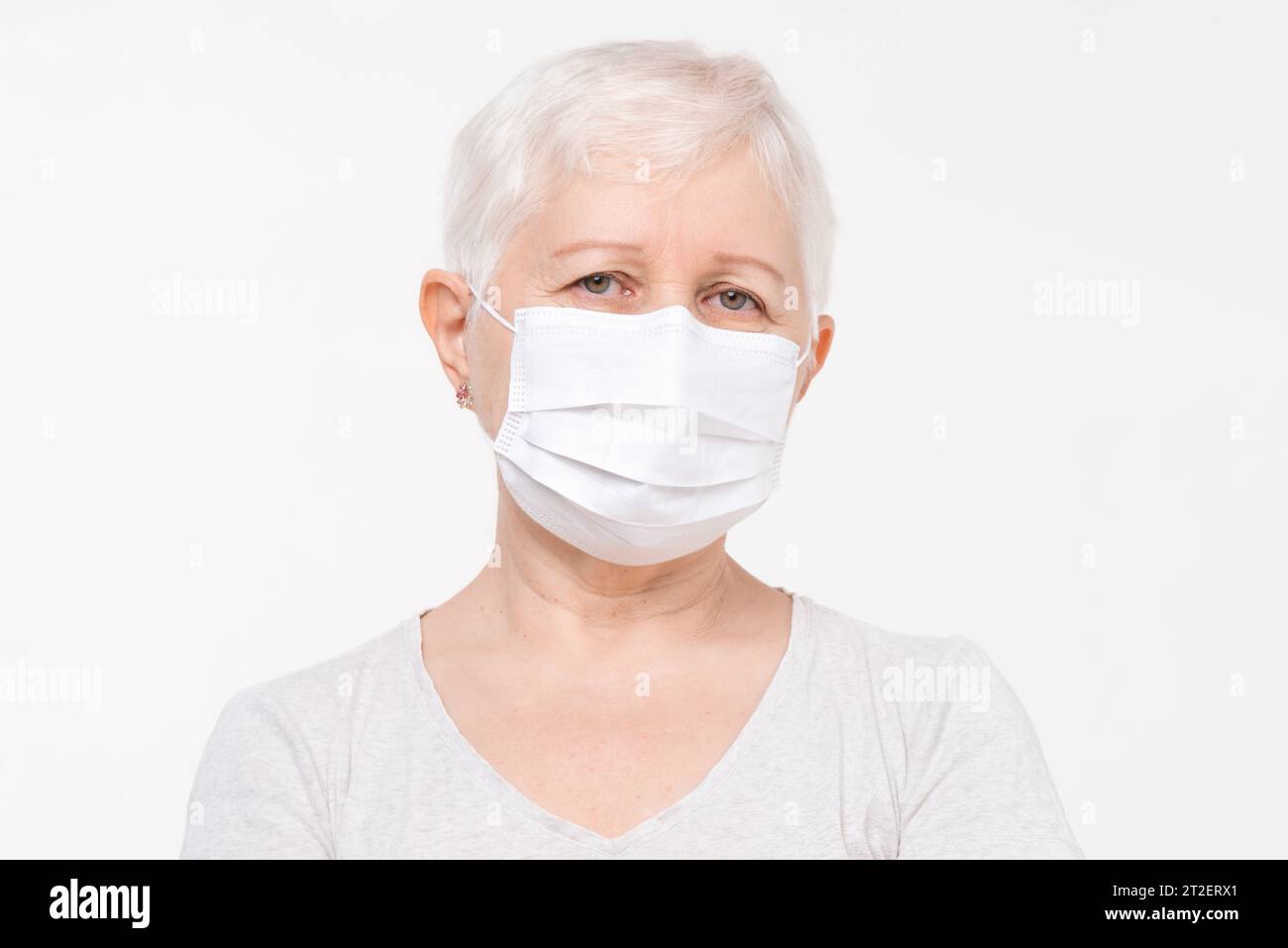 Headshot portrait of elderly Caucasian female wearing medical face mask ...