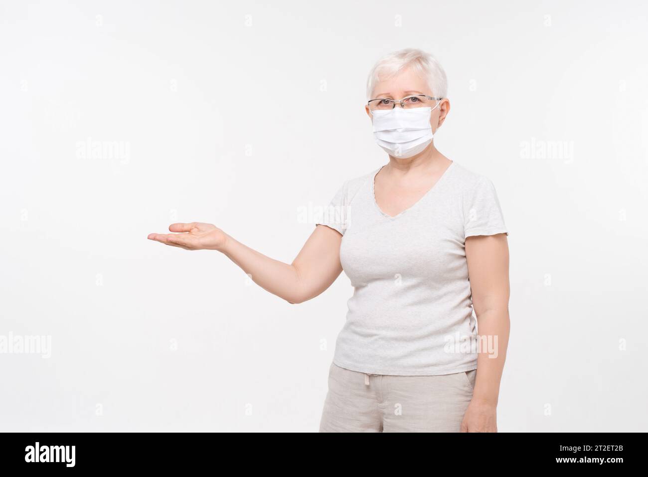 Portrait of elderly Caucasian woman wearing medical face mask with open ...