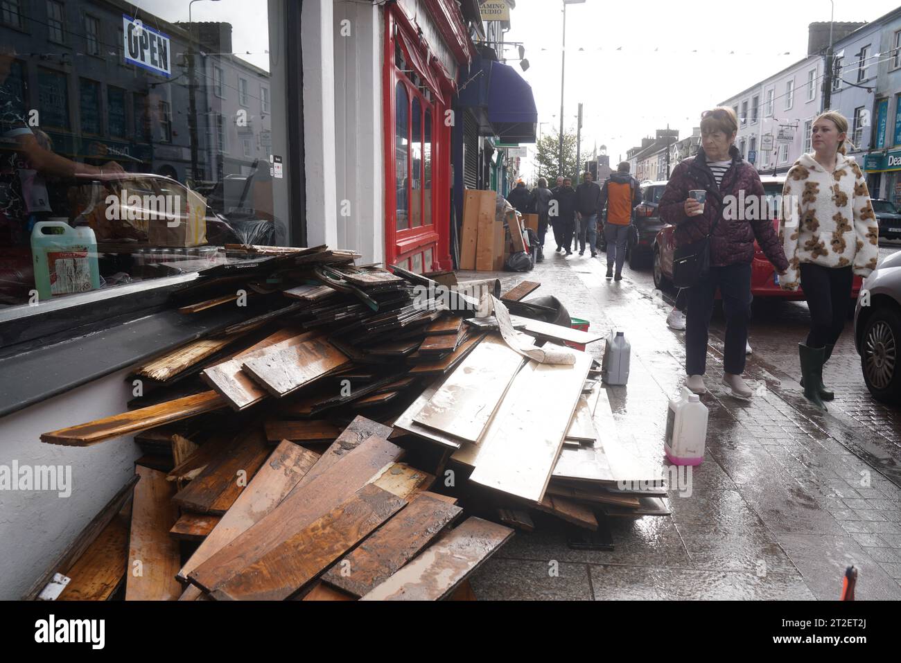 People walk past damaged shops on Main street in Midleton, Co Cork ...