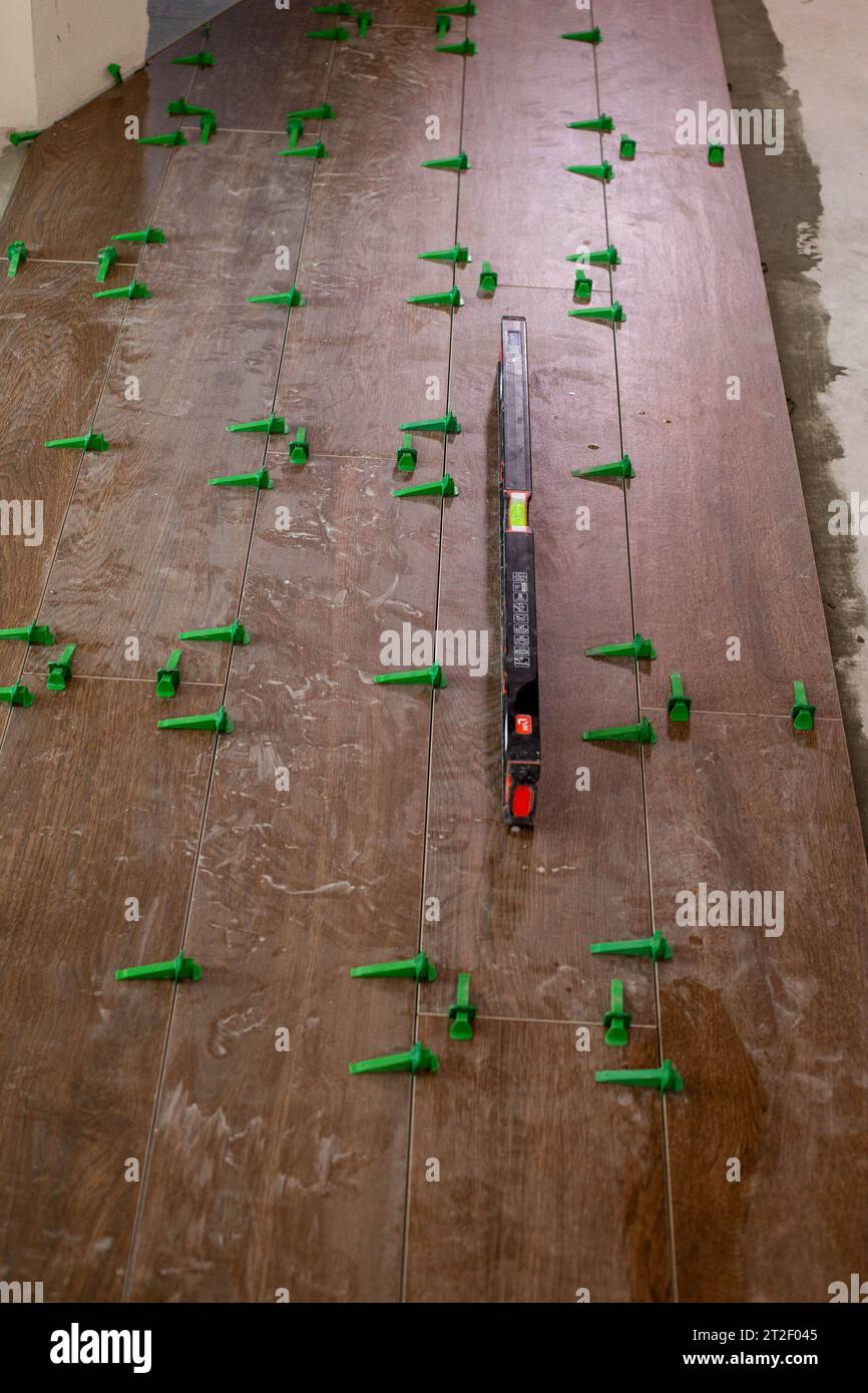 Tile levelling system, four plastic green clips with wedges. Close-up ...