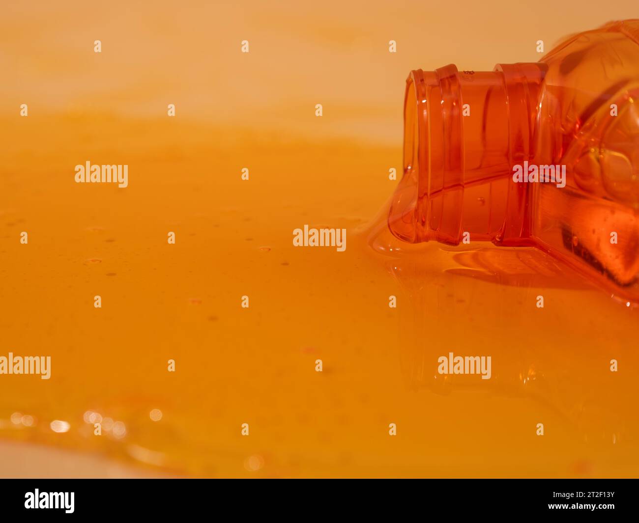 Liquid shower gel gracefully pours from a container onto a bright ...