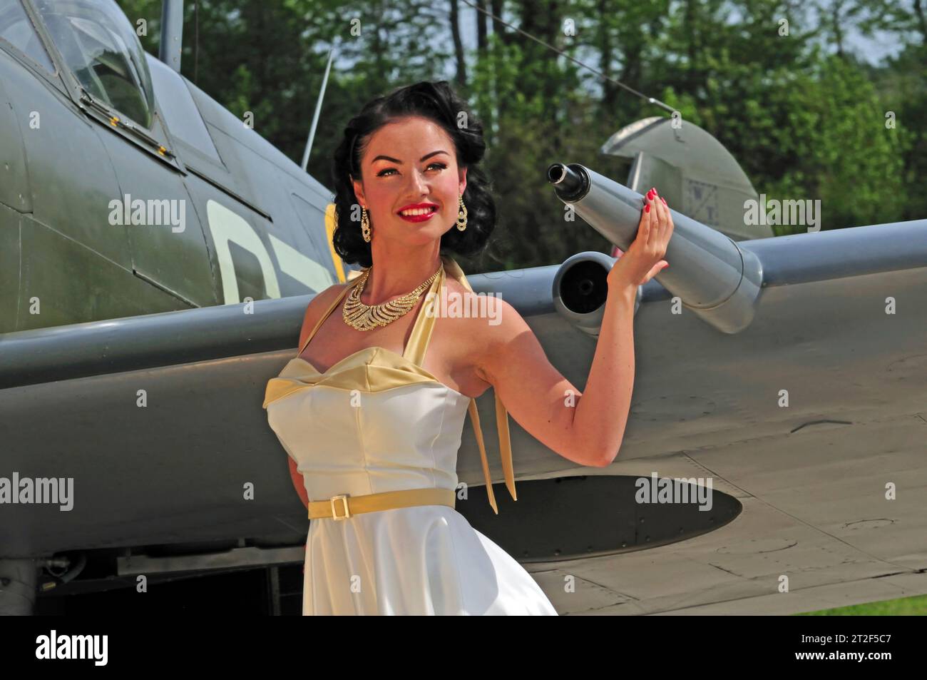 Glamorous 1940's style bombshell close-up with a British Spitfire ...