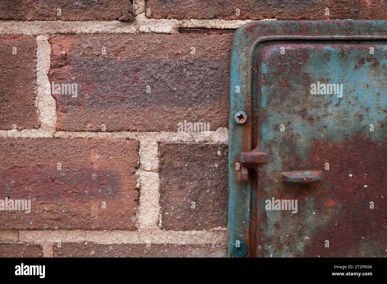 Brick and rusted metal hatch with blue paint Stock Photo - Alamy