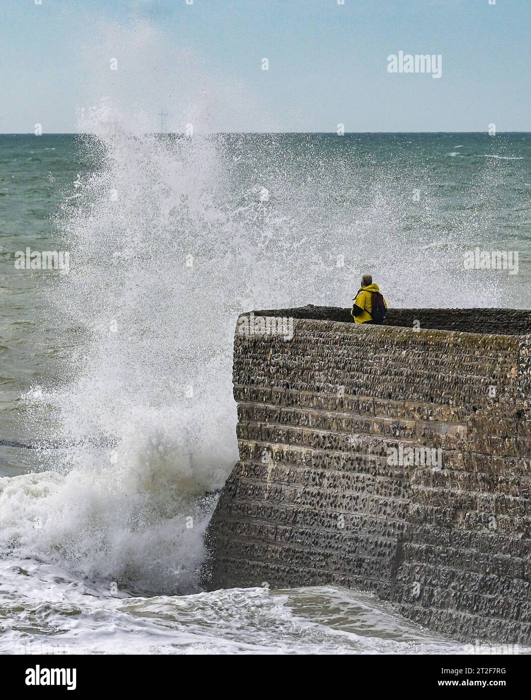Brighton UK 19th October 2023 - A visitor gets wet as waves crash onto ...