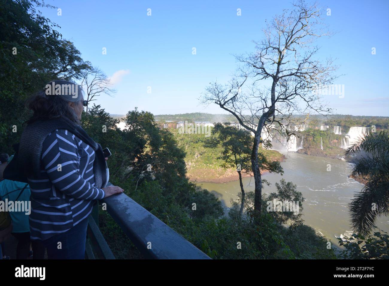 Tourist looking at the Iguaçu Falls, border between Brazil and ...