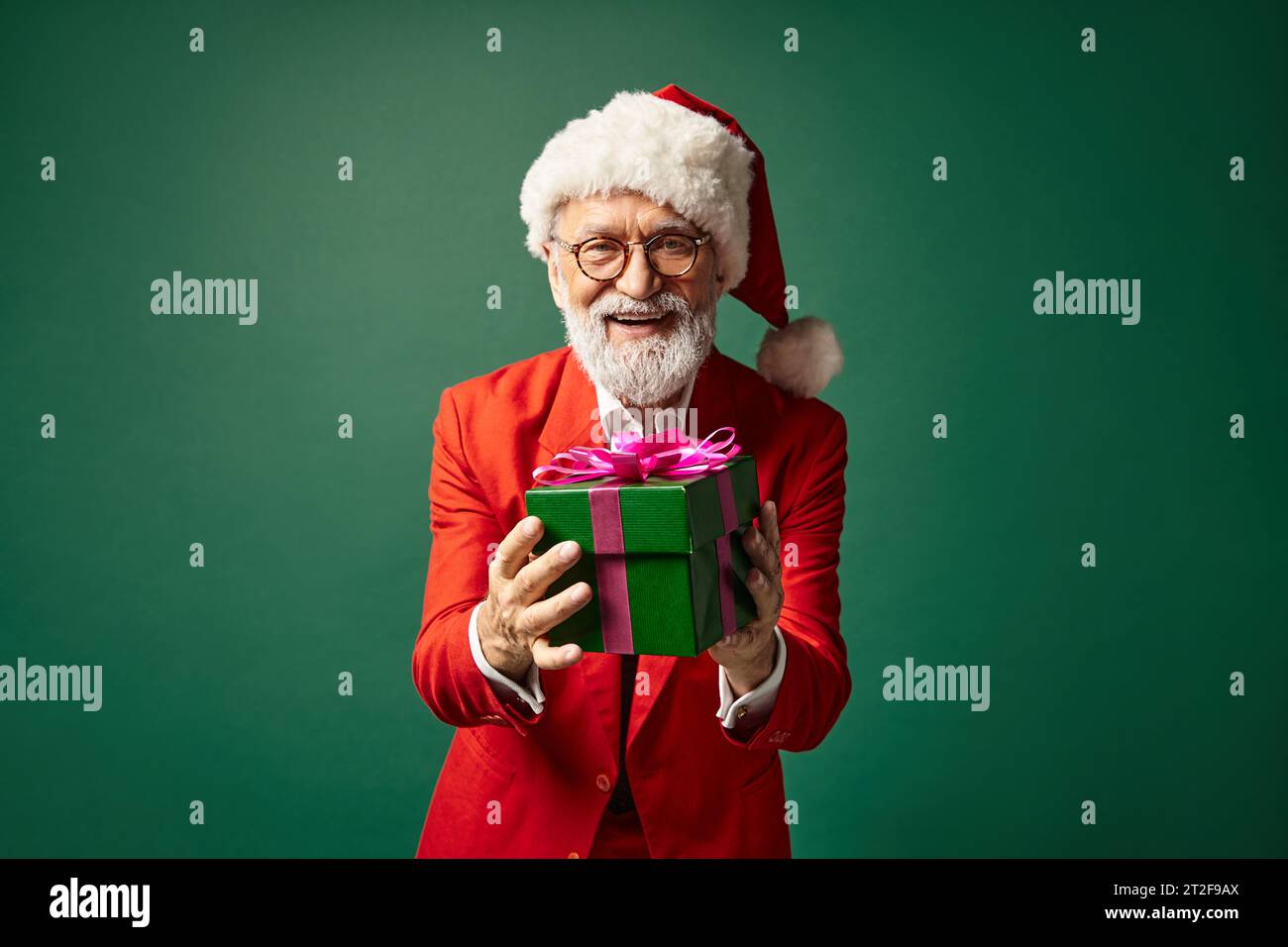 elegant good looking Santa posing with present in hands smiling ...