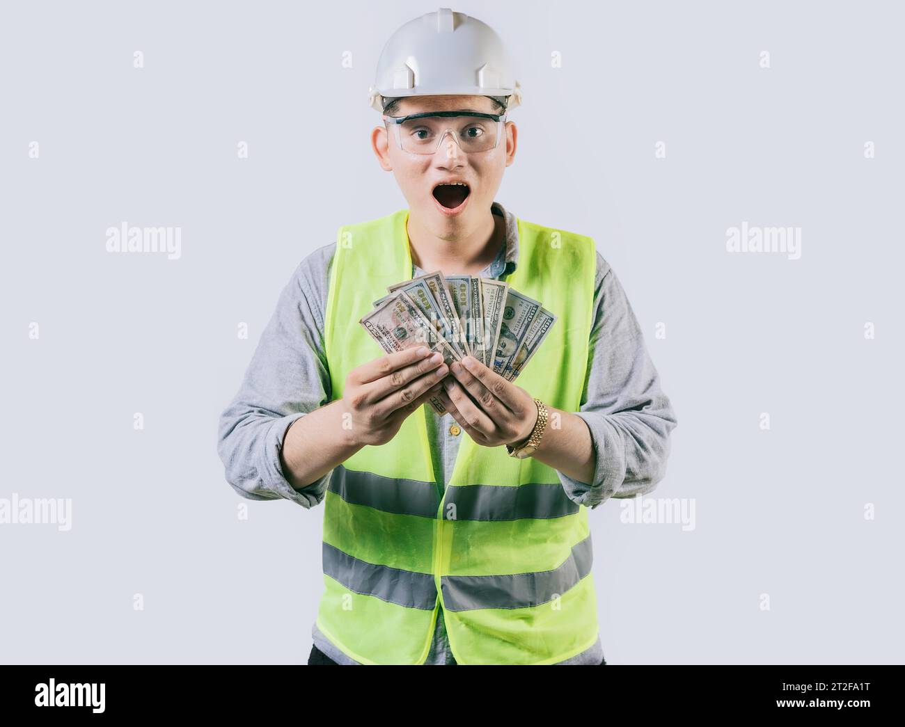 Surprised engineer in helmet holding money isolated. Amazed male ...