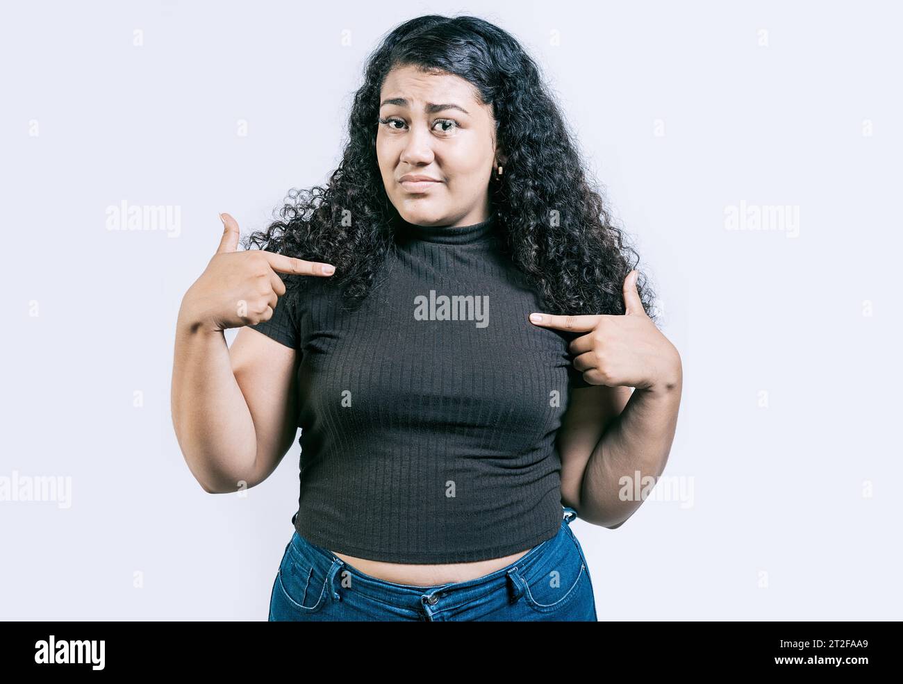 Confused girl pointing at herself isolated. Embarrassed young woman ...