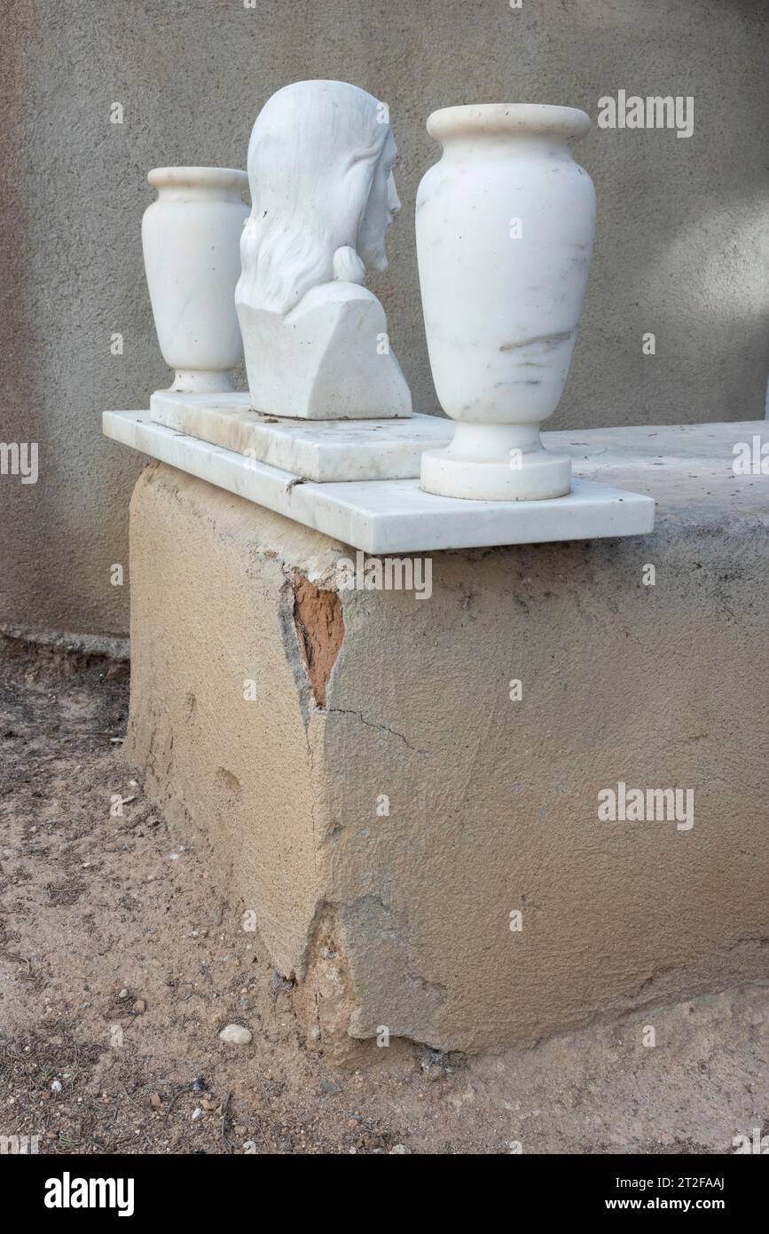 Simple grave with crumbling plaster, white god figure and empty white ...