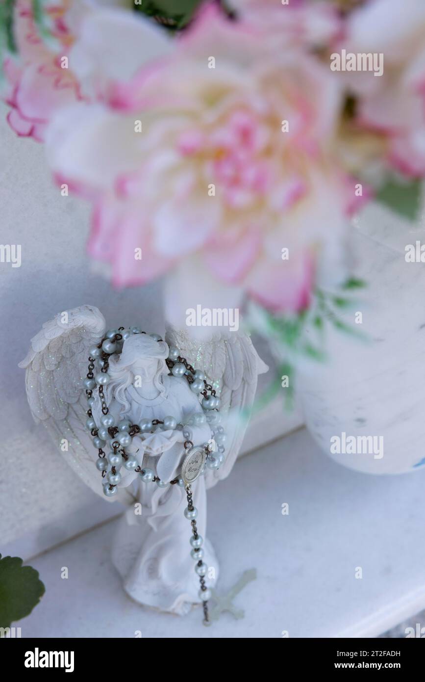 Small angel figure, hung with a rosary chain on an urn grave in a ...