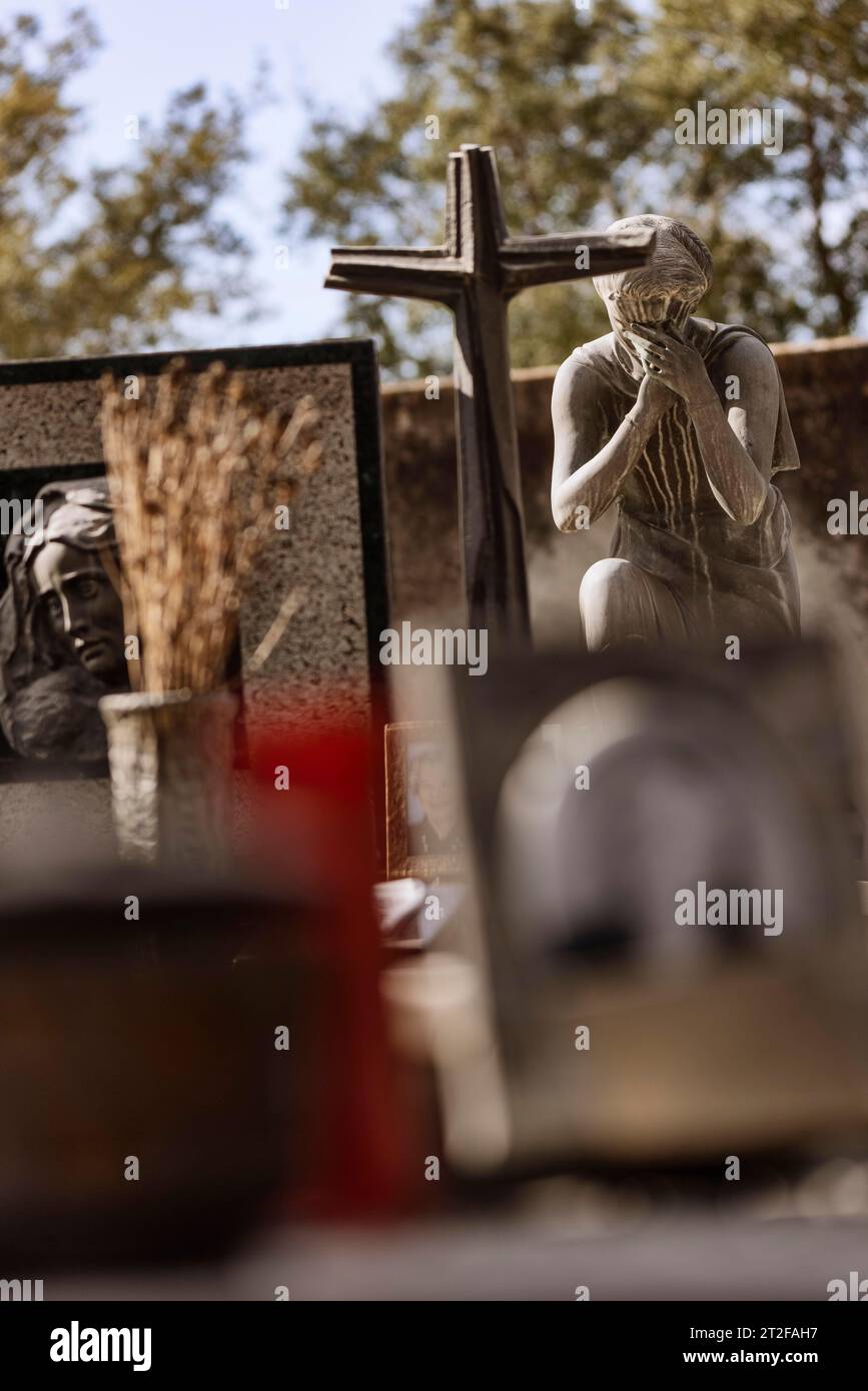 Mourning female figure in front of a cross in a cemetery, Bari Sardo ...