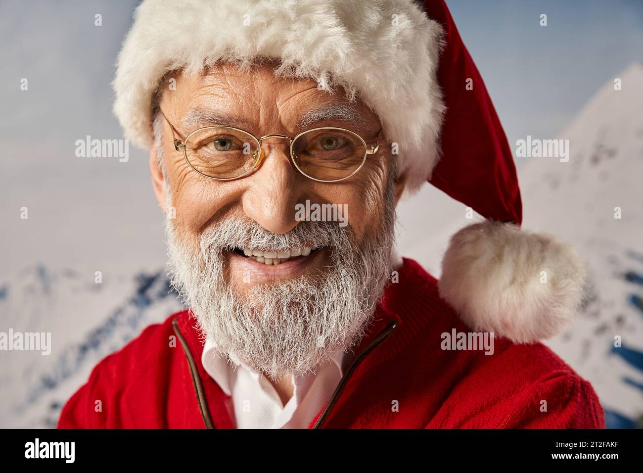 portrait of happy white bearded Santa in red hat with glasses with ...