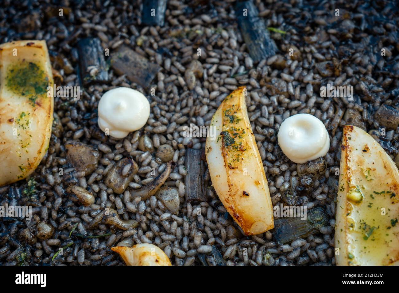 Detail of the black rice with cuttlefish and young garlic with aioli, a ...