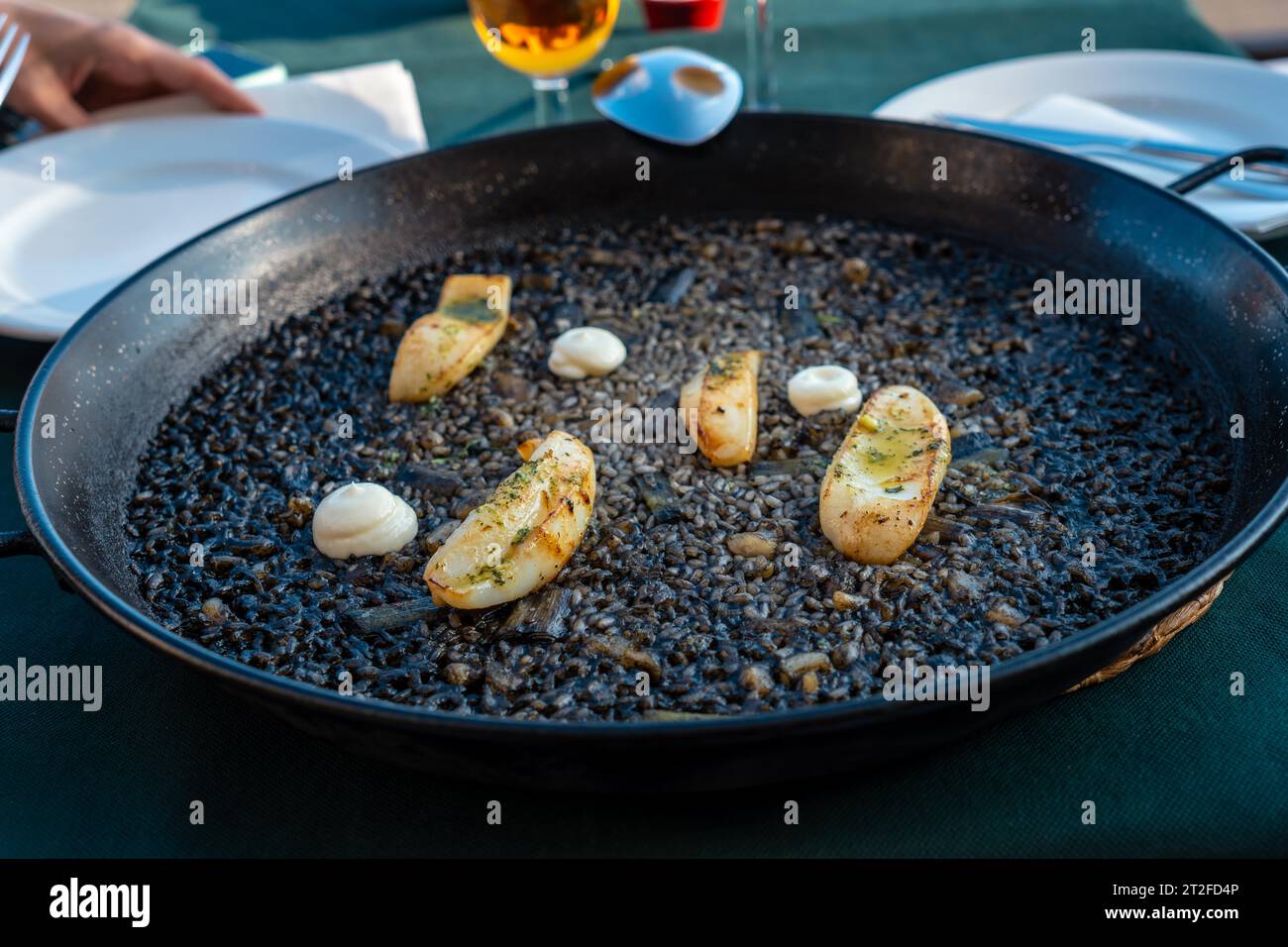 Black rice with cuttlefish and young garlic, a dry rice dish, cooked in ...
