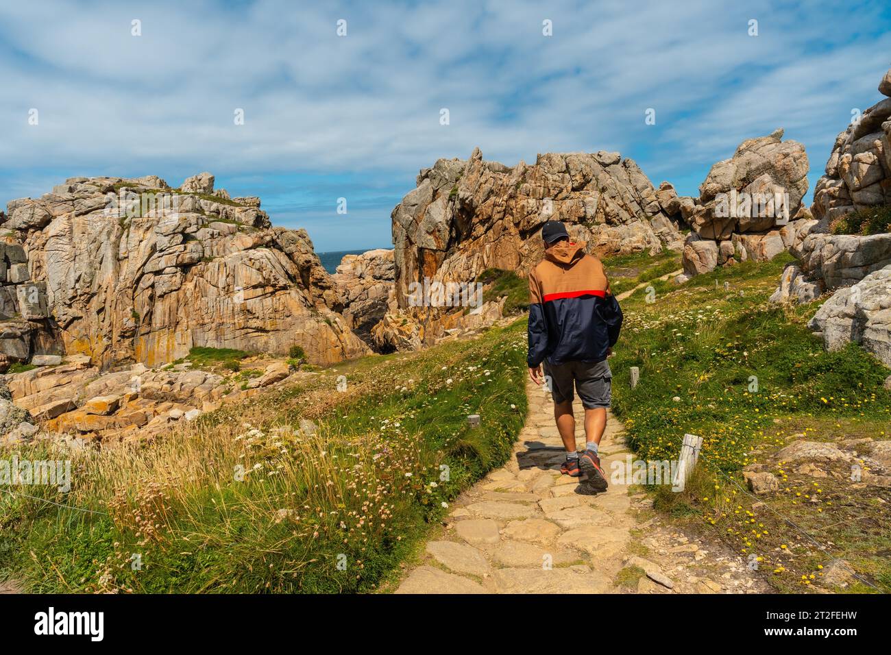 A young tourist walking the trails of Le Gouffre de Plougrescant, Cote ...