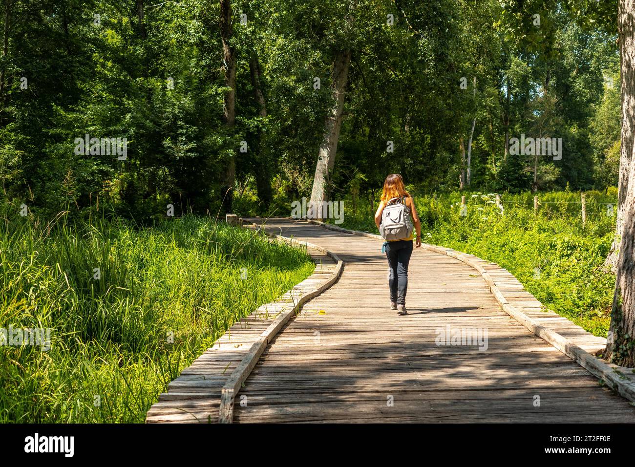 A young woman on the footpath along a footbridge between La Garette and ...