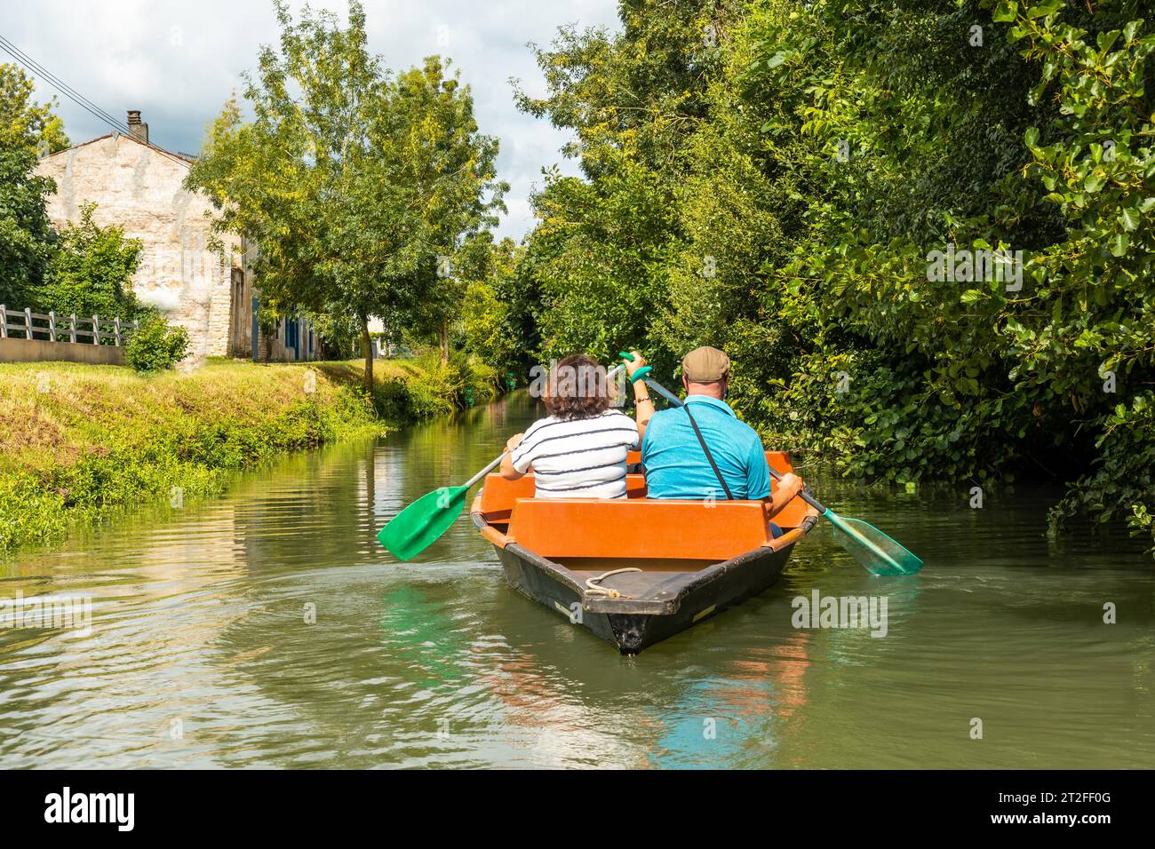 A couple rowing the boat sailing between La Garette and Coulon, Marais ...
