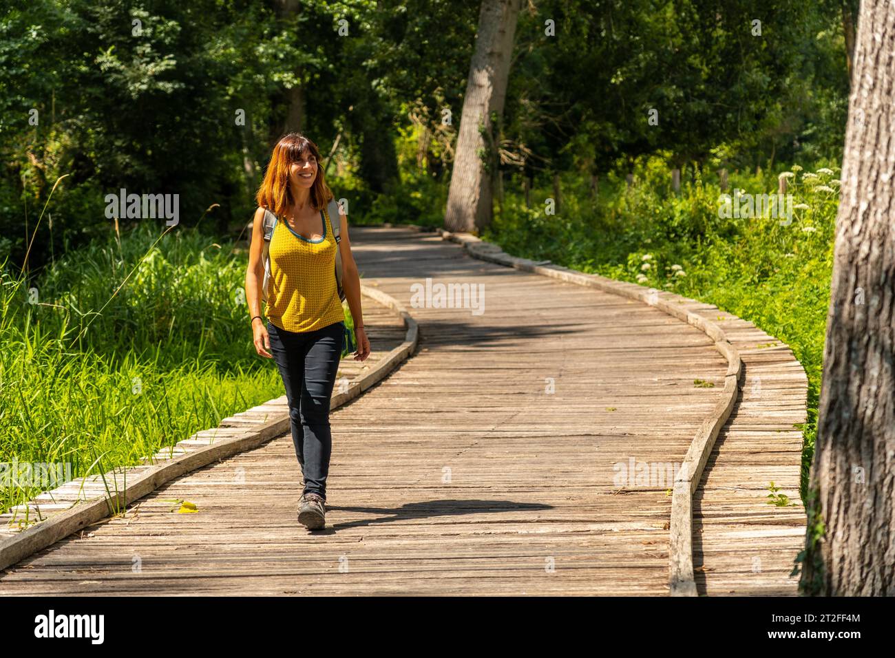 A young woman trekking on the footpath along a footbridge between La ...
