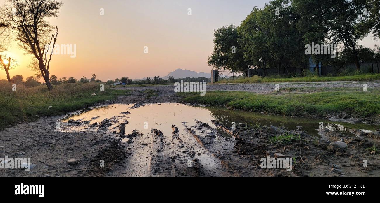 A patch of wet ground with puddles of water surrounding it in a rural ...