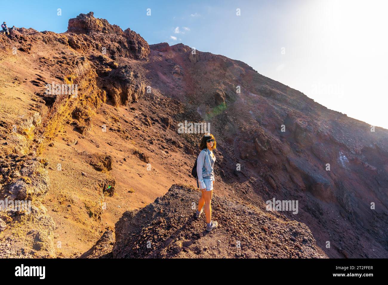 A young woman looking at the crater of the Teneguia volcano on the ...