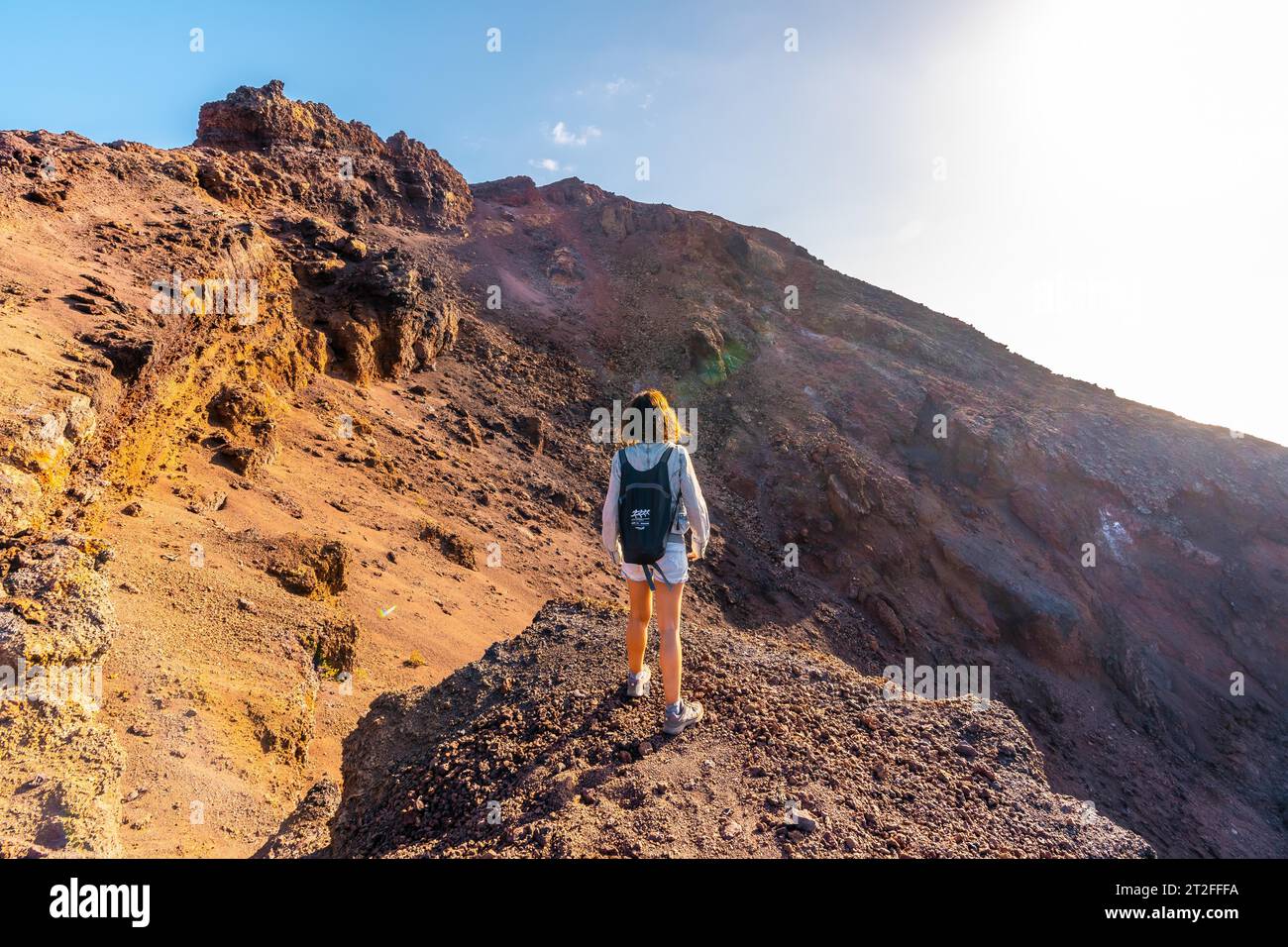 A young woman looking at the crater of the Teneguia volcano on the ...
