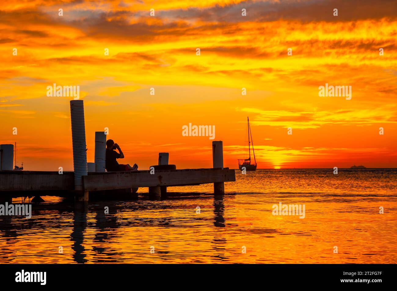 Roatan, Honduras Â», January 2020: A young man photographing the sunset ...
