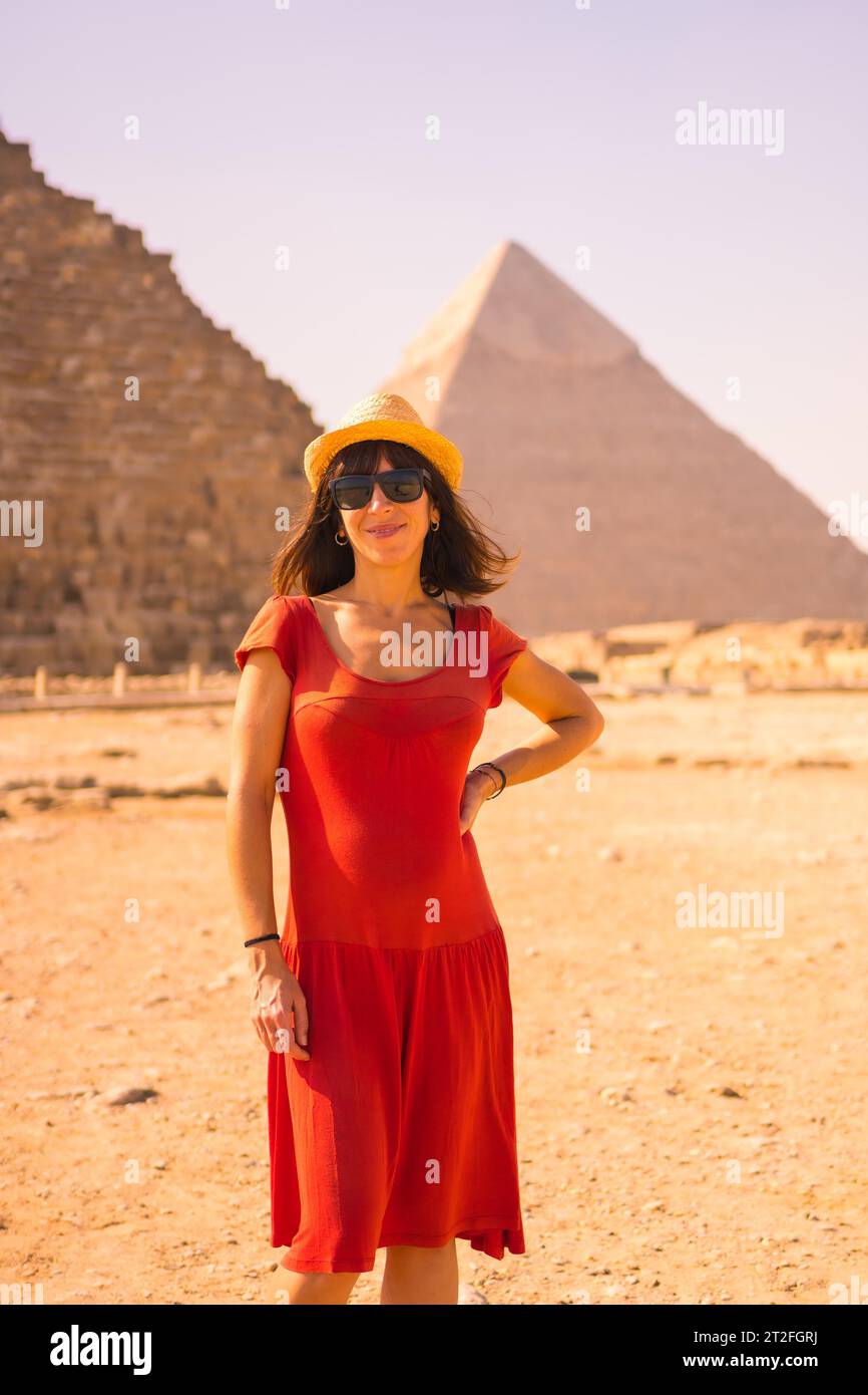 Portrait of a young girl in red dress at the pyramid of Cheops the ...