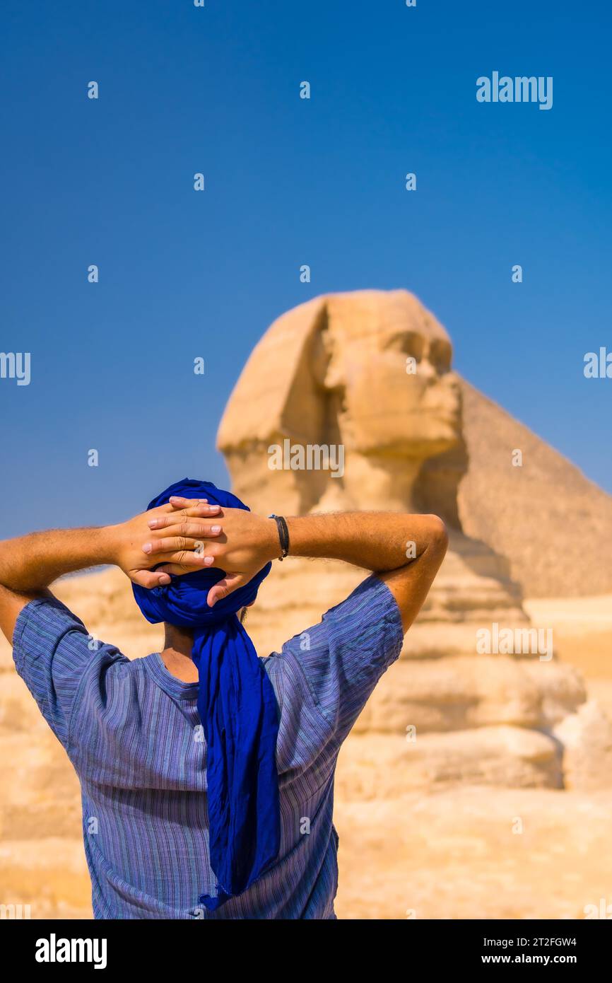 A young tourist enjoying and admiring the Great Sphinx of Giza dressed ...