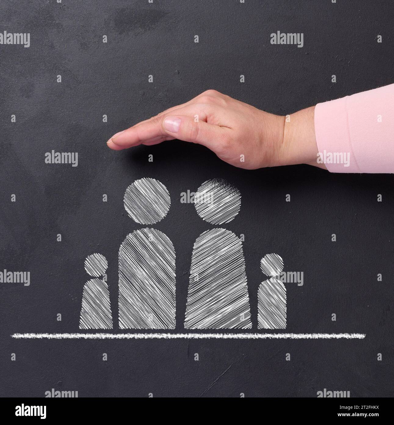 Chalk-drawn family on a blackboard with a hand above, symbolizing the ...