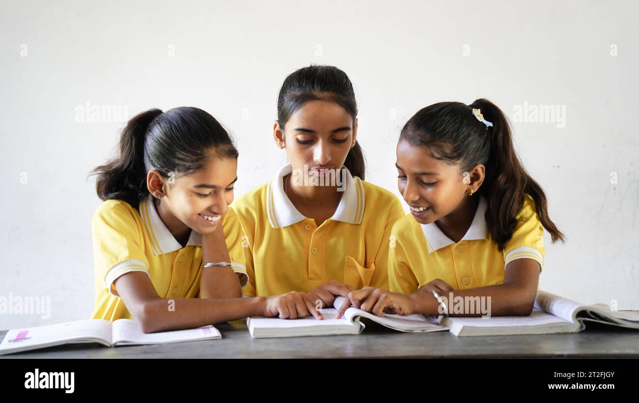 Happy Indian elementary school girls students sitting at desk in ...