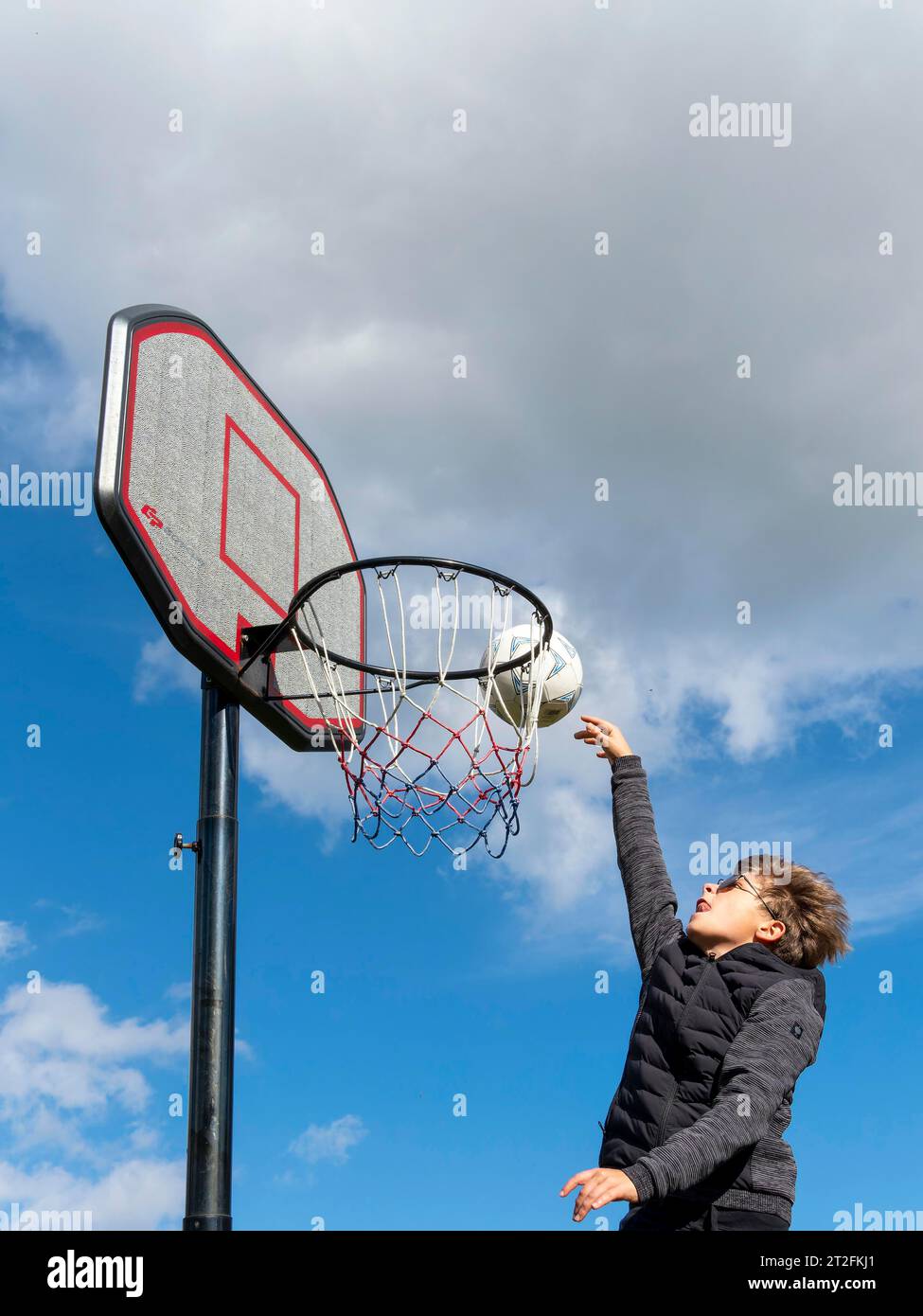 Basketball jumping with the ball to the basket and net, boy 10 years ...