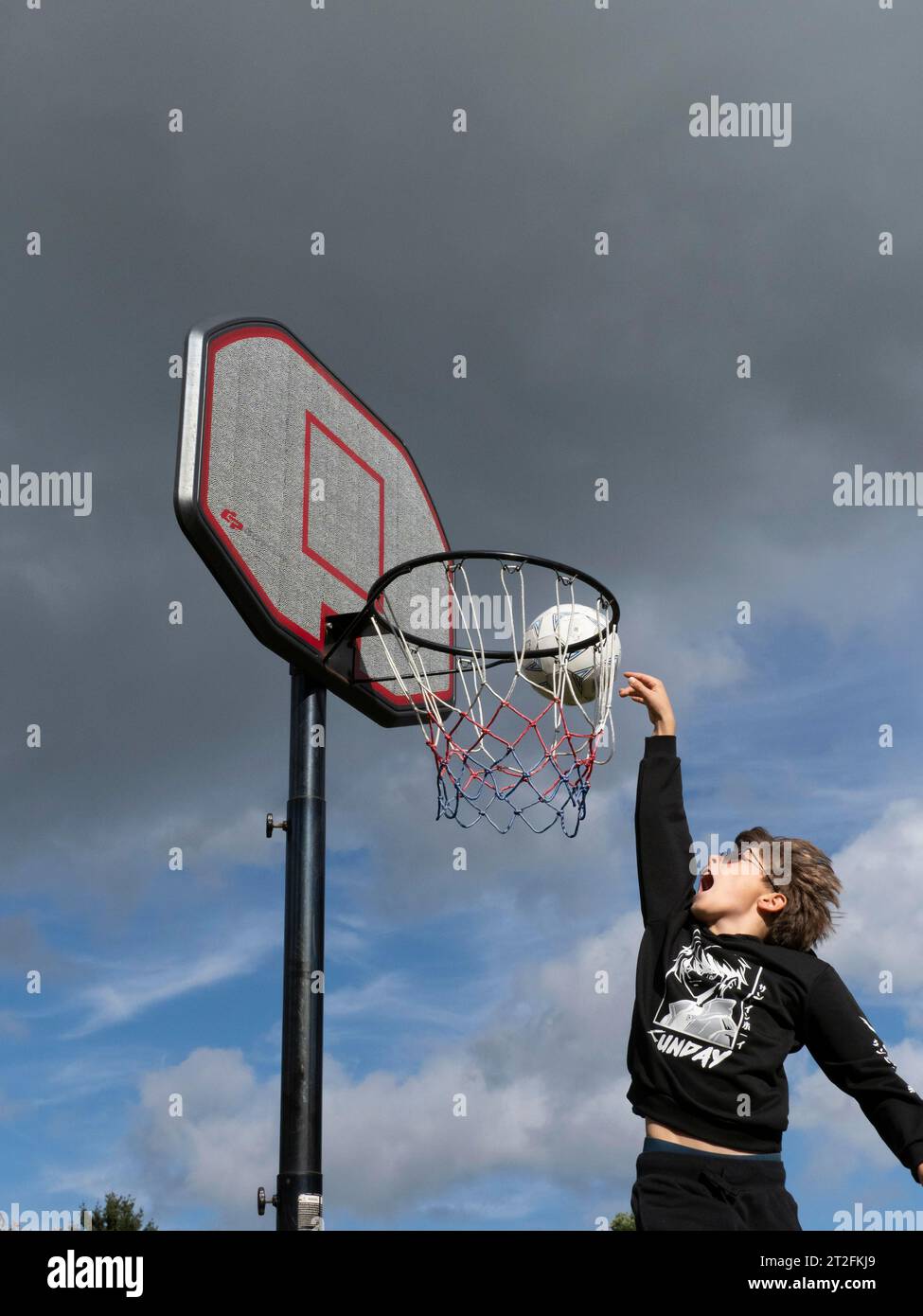 Basketball jumping with the ball to the basket and net, boy 10 years ...