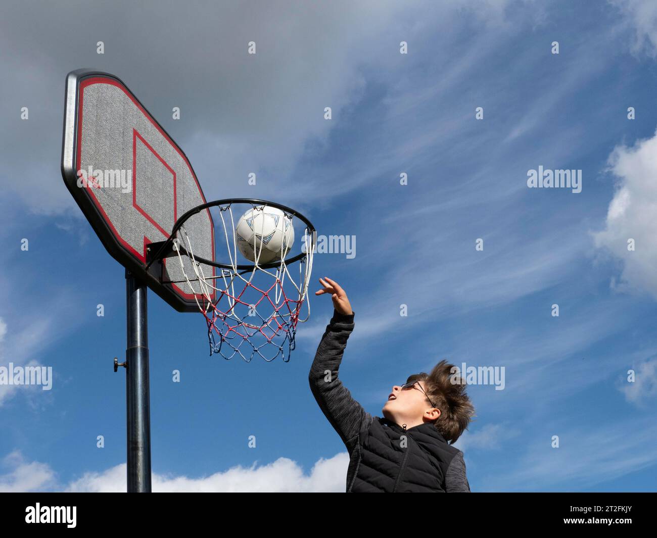 Basketball jumping with the ball to the basket and net, boy 10 years ...