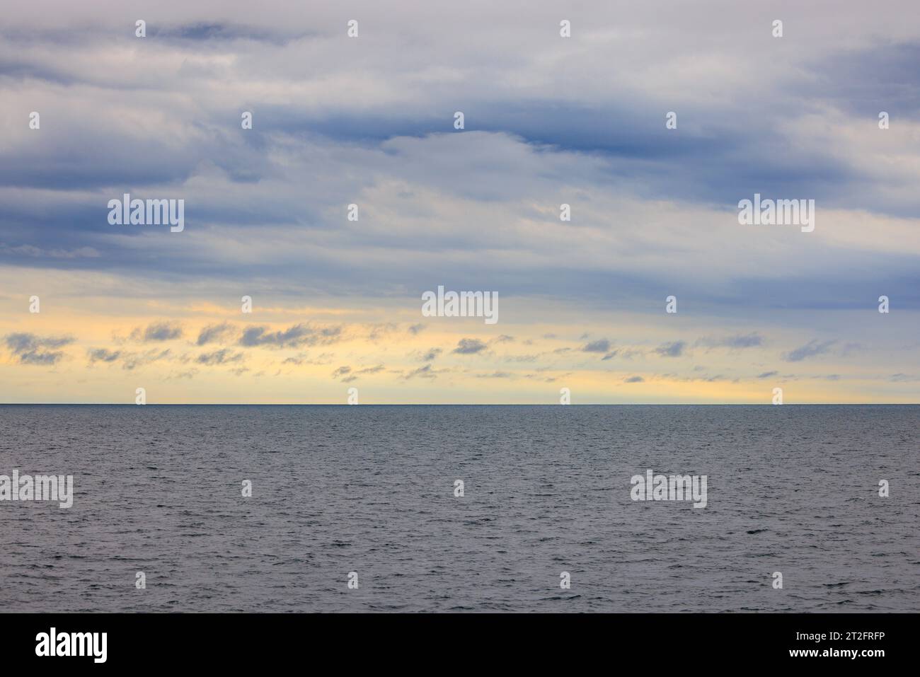Distant horizon between cloud layer and calm seas at sunrise Stock ...