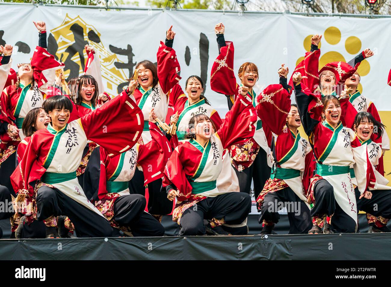 Young Japanese women team of Yosakoi dancers, kneeling and standing ...