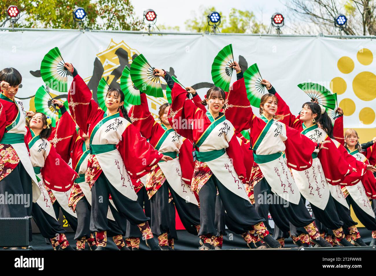 Young Japanese women team of Yosakoi dancers, all holding open fans ...