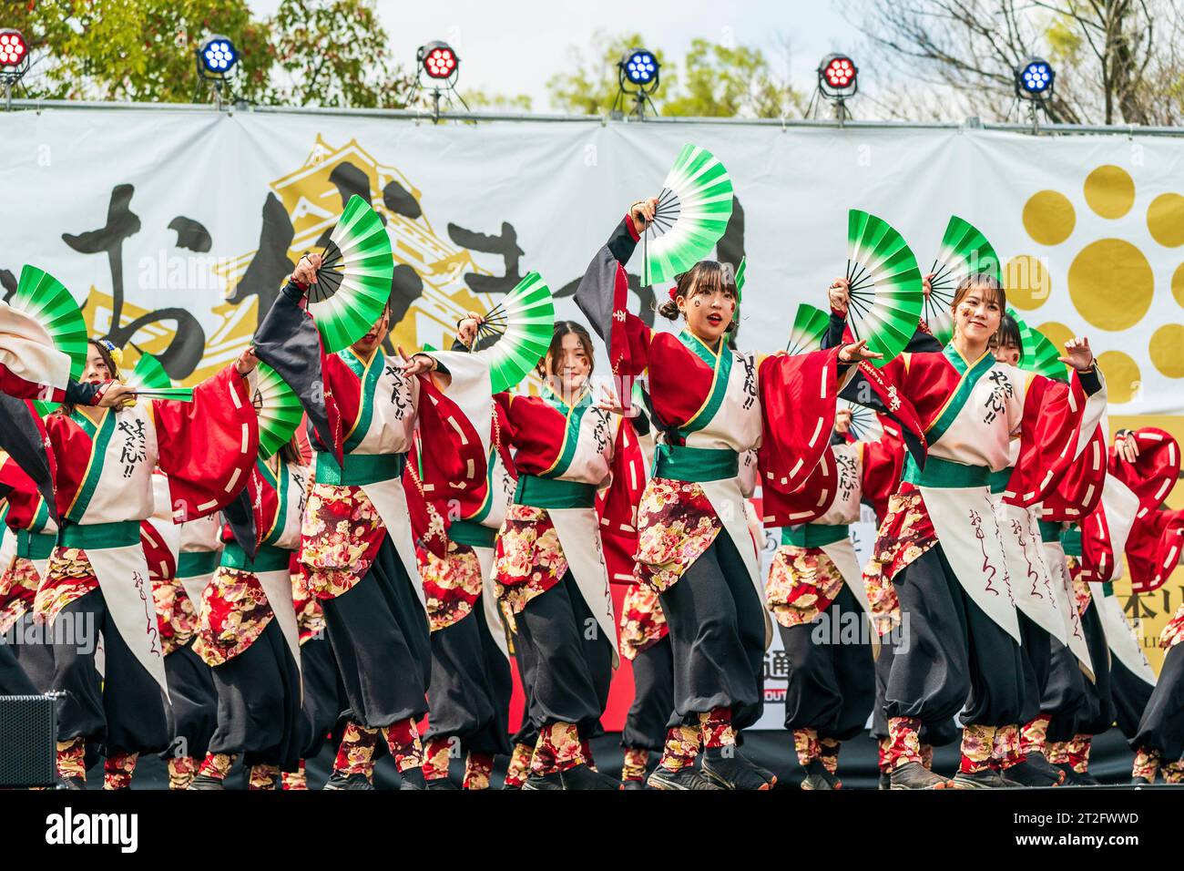 Young Japanese women team of Yosakoi dancers, all holding open fans ...
