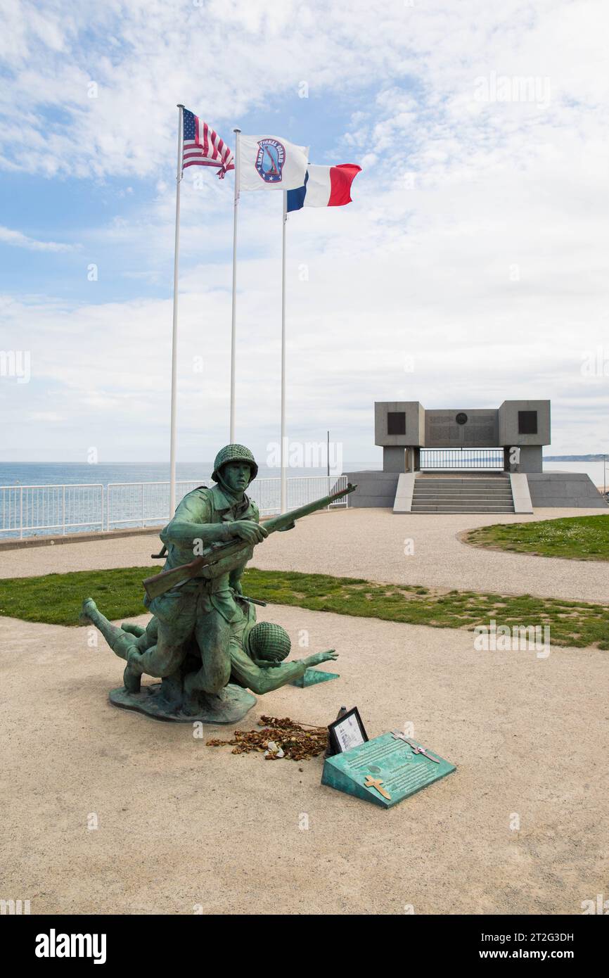 Omaha beach memorial statue of a soldier carrying a rifle and helping ...