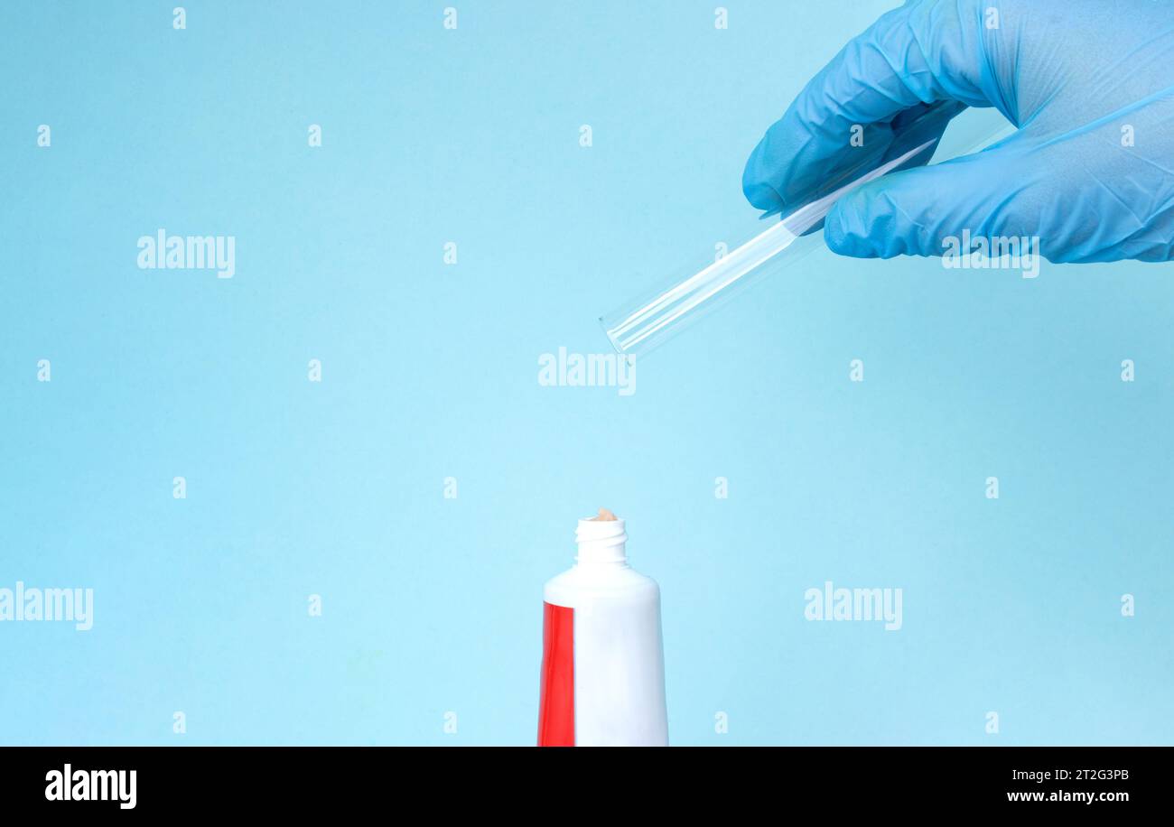 Doctors hands in blue gloves hold glass tube with calcium under ...