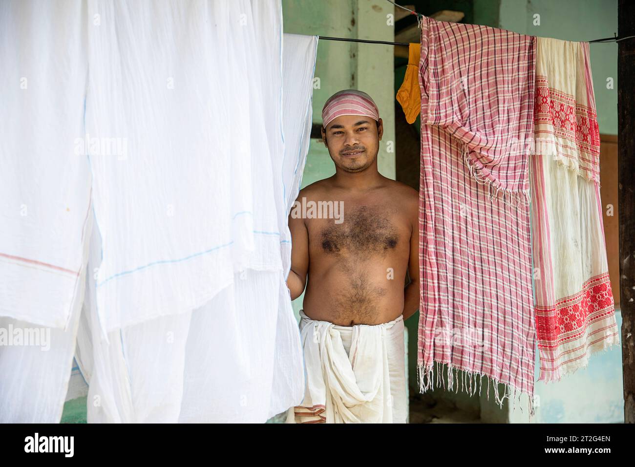 Hindu monk in traditional clothes standing by drying clothes at the ...
