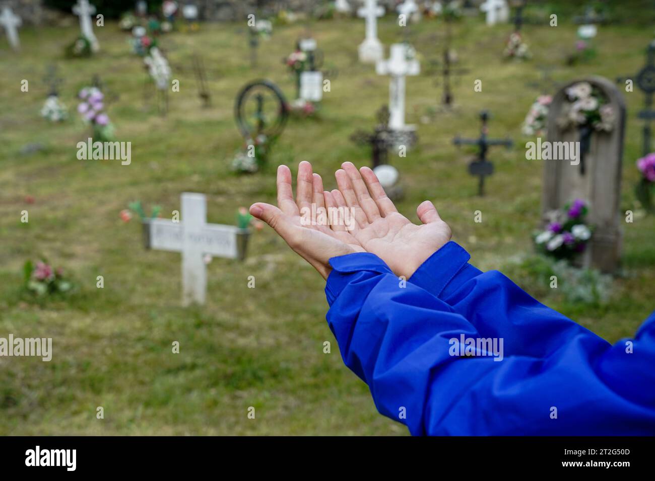 hands together in a graveyard. Trust and support with faith. Day of the ...