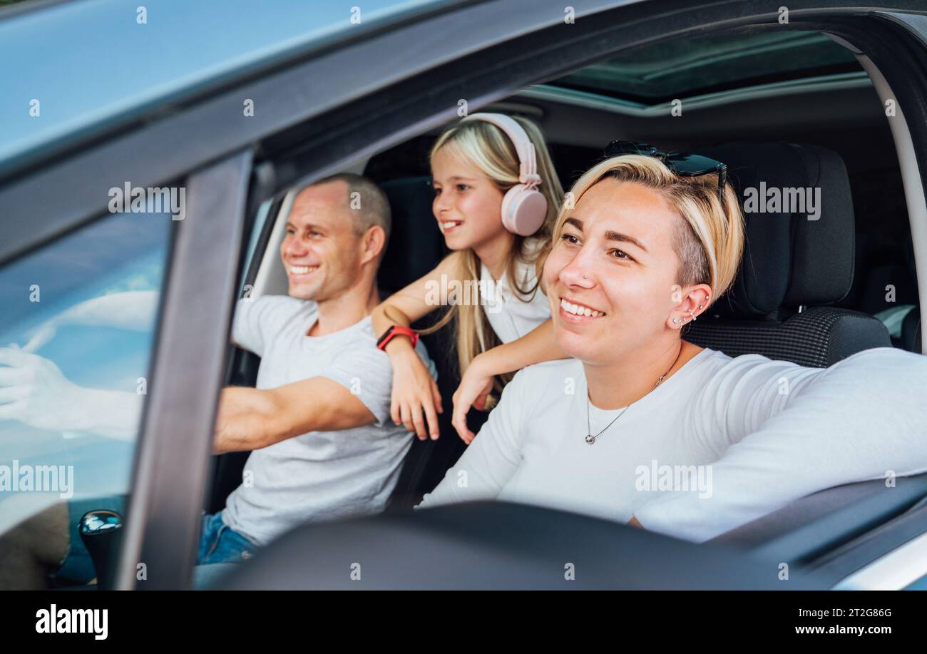 Cheerful young traditional family has a auto journey in modern car ...