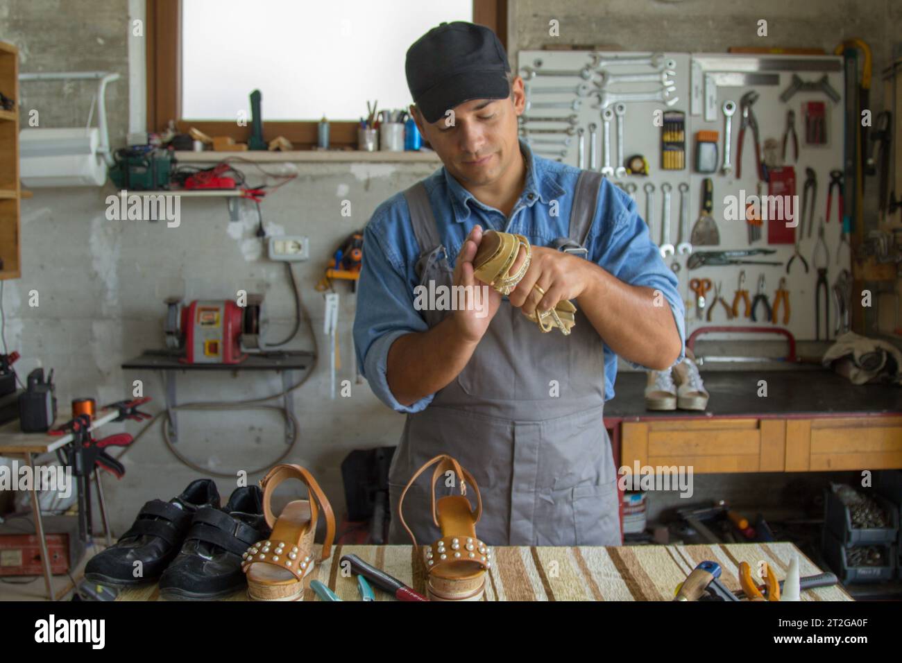 Image of a craftsman gluing the sole of a woman's shoe. Old professions ...