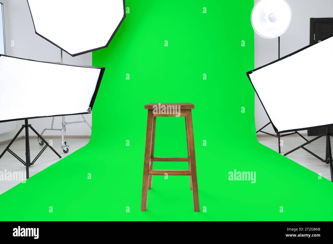 Chroma key compositing. Green backdrop, stool and equipment in studio ...