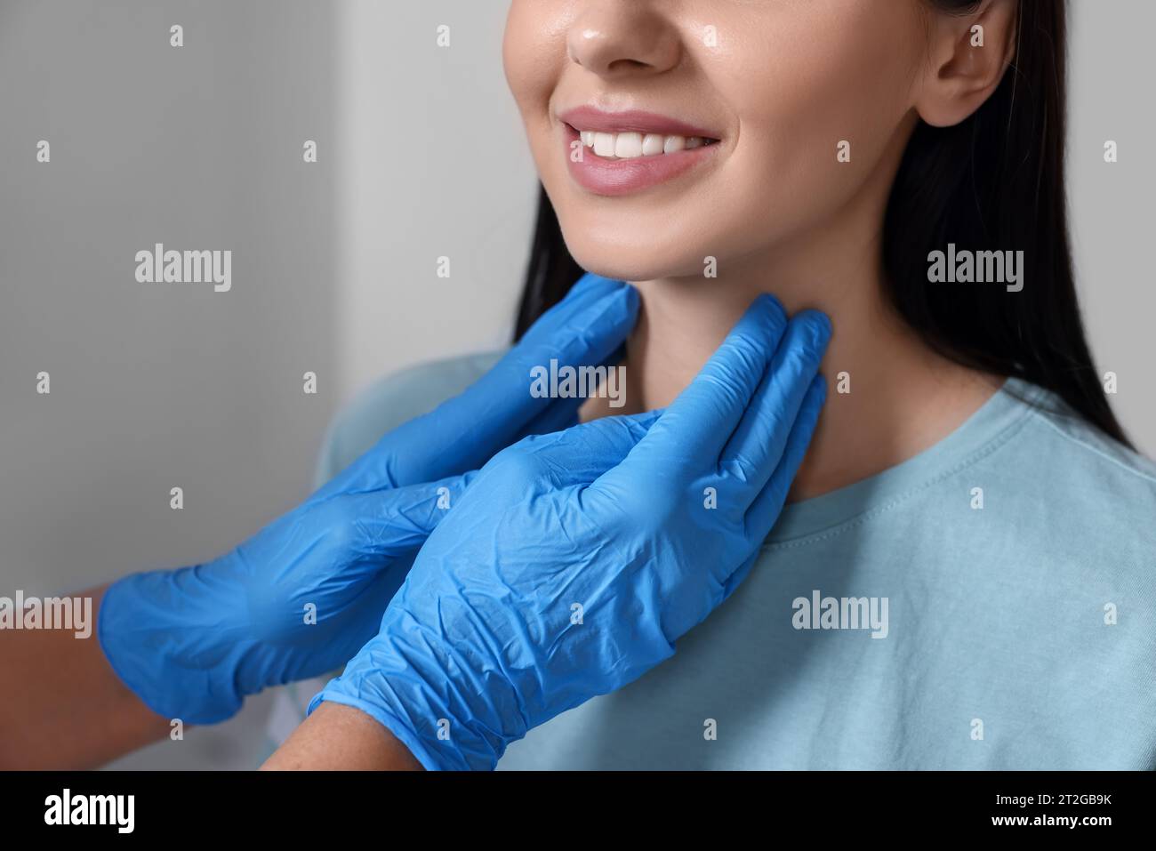 Endocrinologist examining thyroid gland of patient indoors, closeup ...