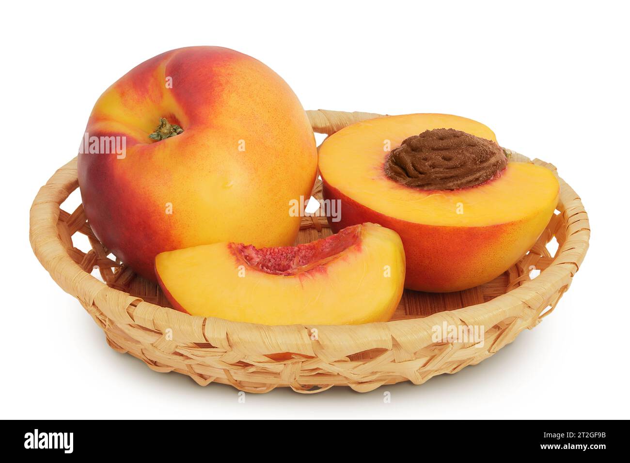 Ripe nectarine fruit with half in a wicker basket isolated on white ...