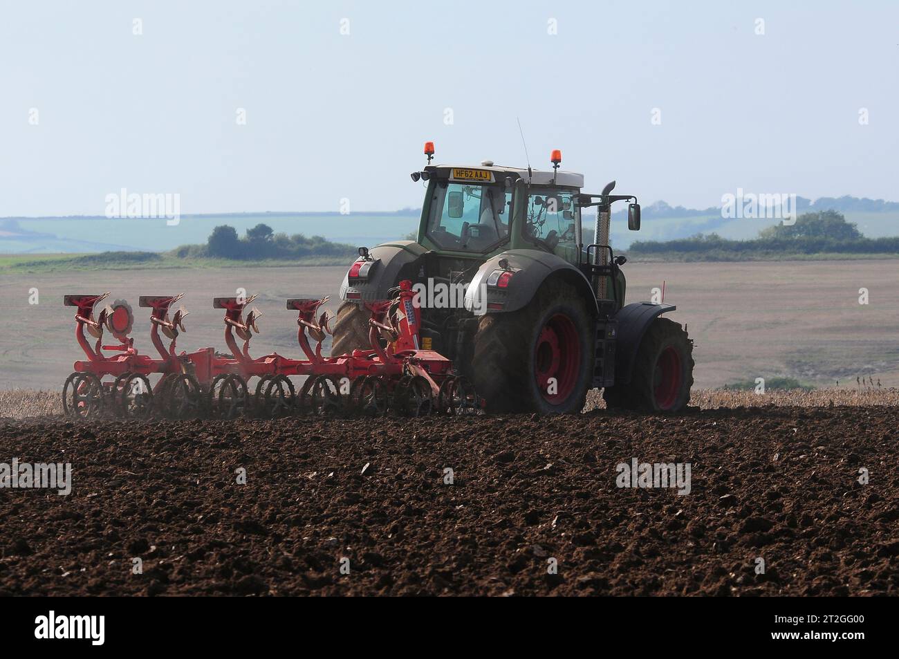 Tractor ploughing corn field after the harvest Stock Photo - Alamy