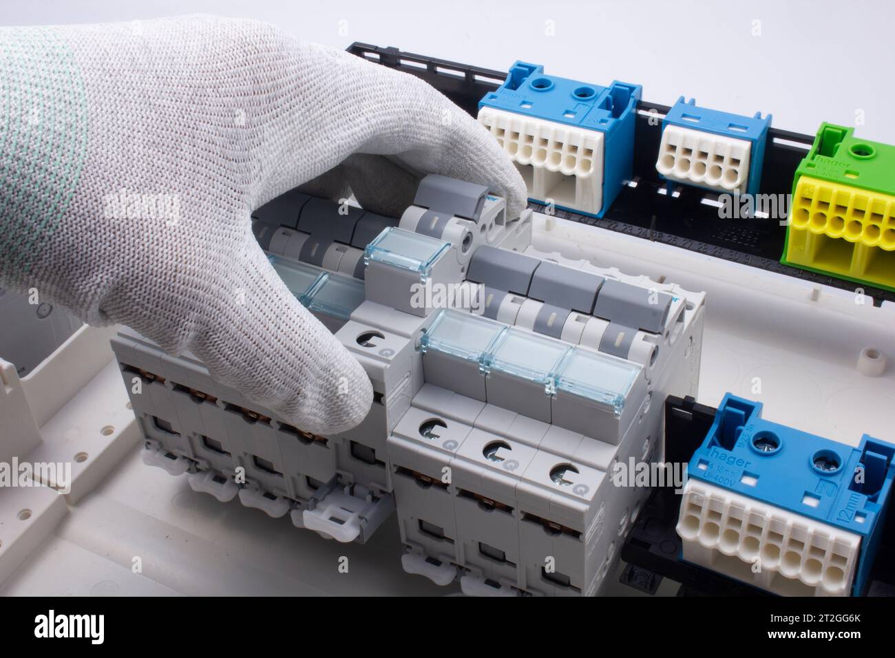 An electrician installs fuses on the TH35 rail in the electrical ...