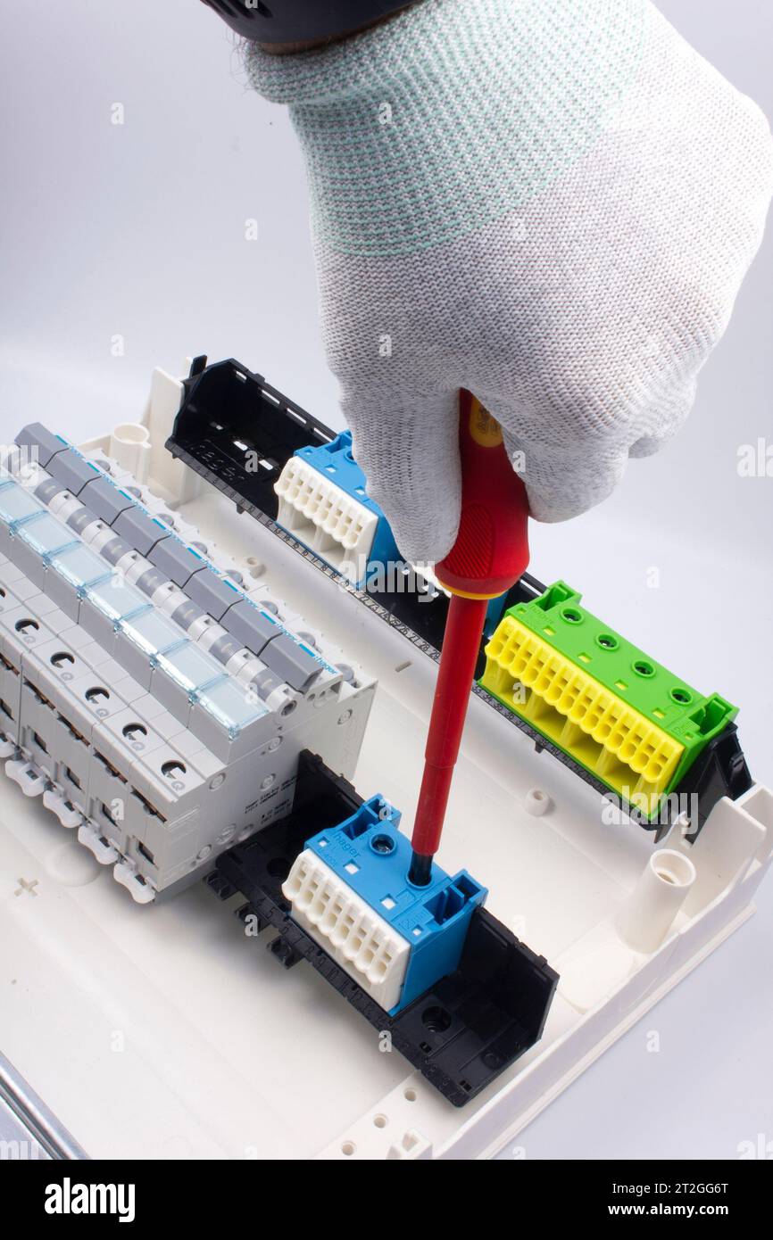 An electrician installs fuses on the TH35 rail in the electrical ...